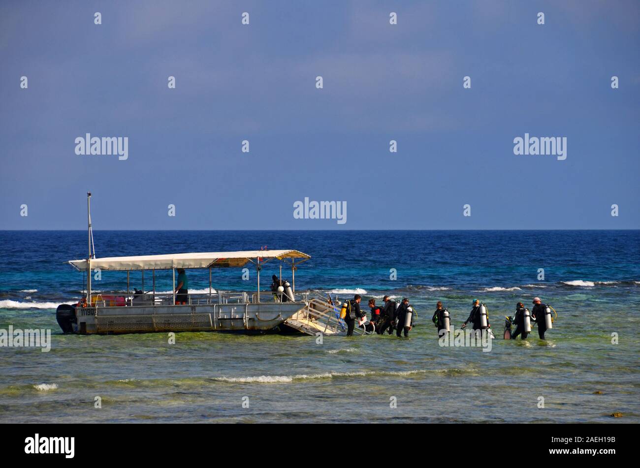 Divers climb aboard a dive boat in the lagoon on Lady Elliot Island ...