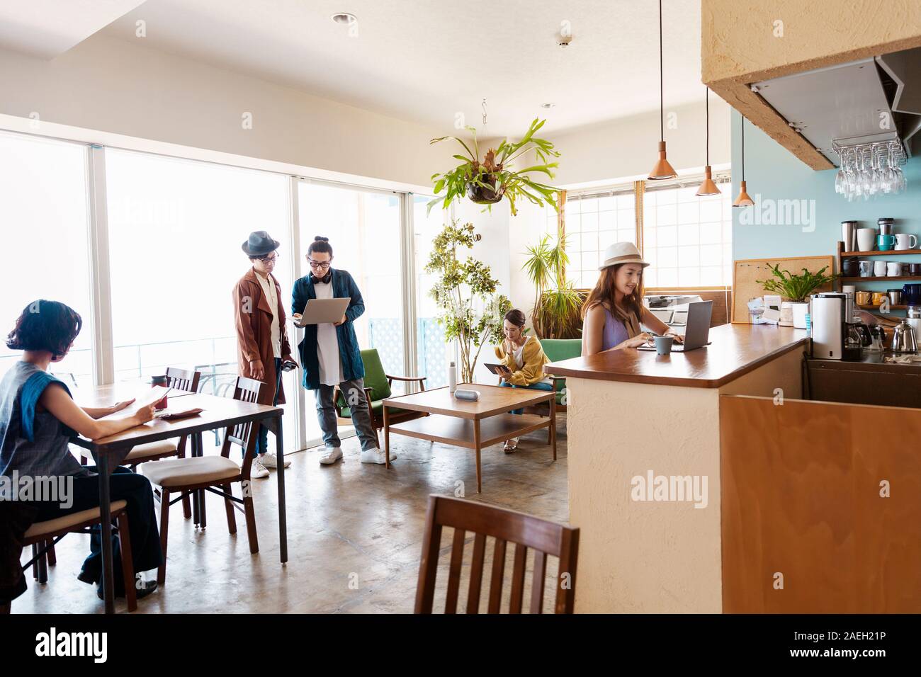 Group of young Japanese professionals working on laptop computers in a ...
