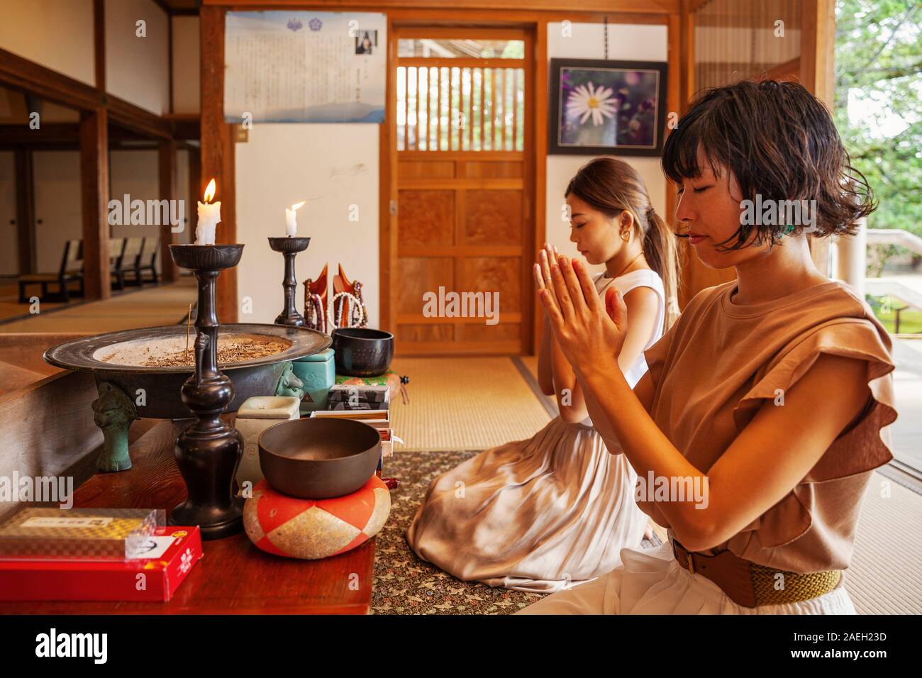 Two Japanese women kneeling in Buddhist temple, praying Stock Photo - Alamy