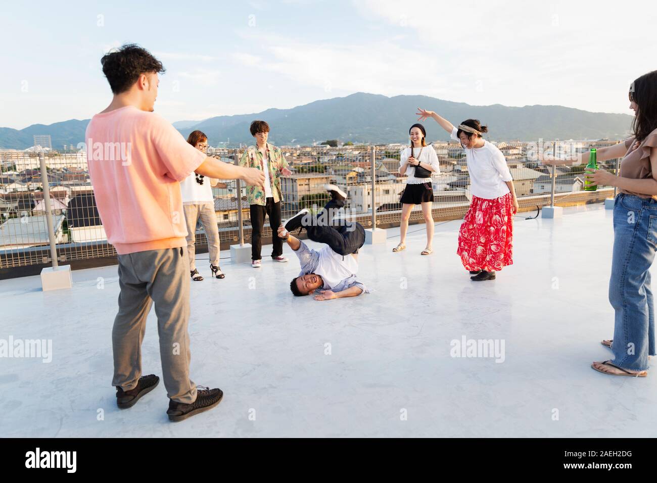 Group of young Japanese men and women dancing on a rooftop in an urban ...