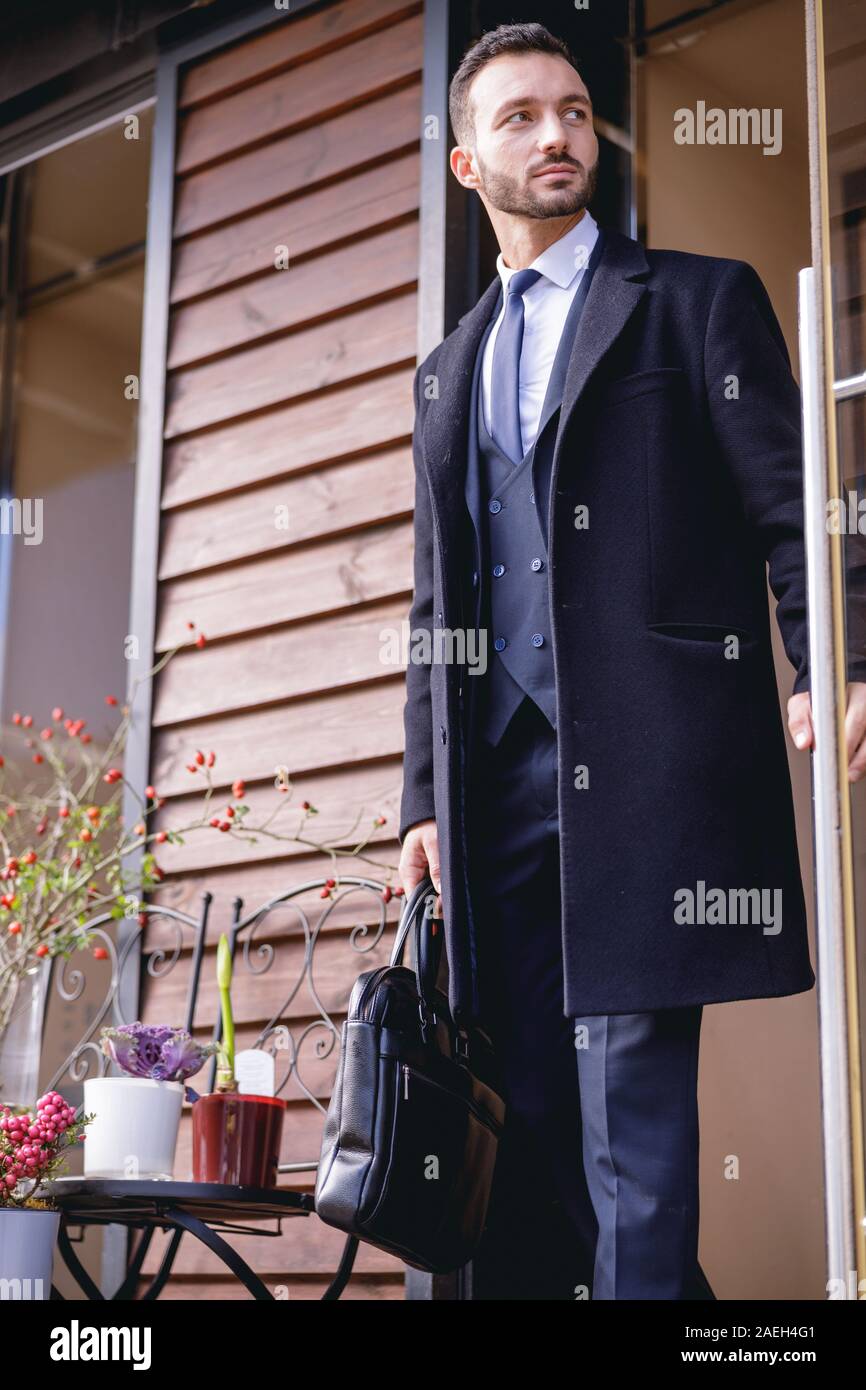 Kind young man standing near glass door Stock Photo - Alamy