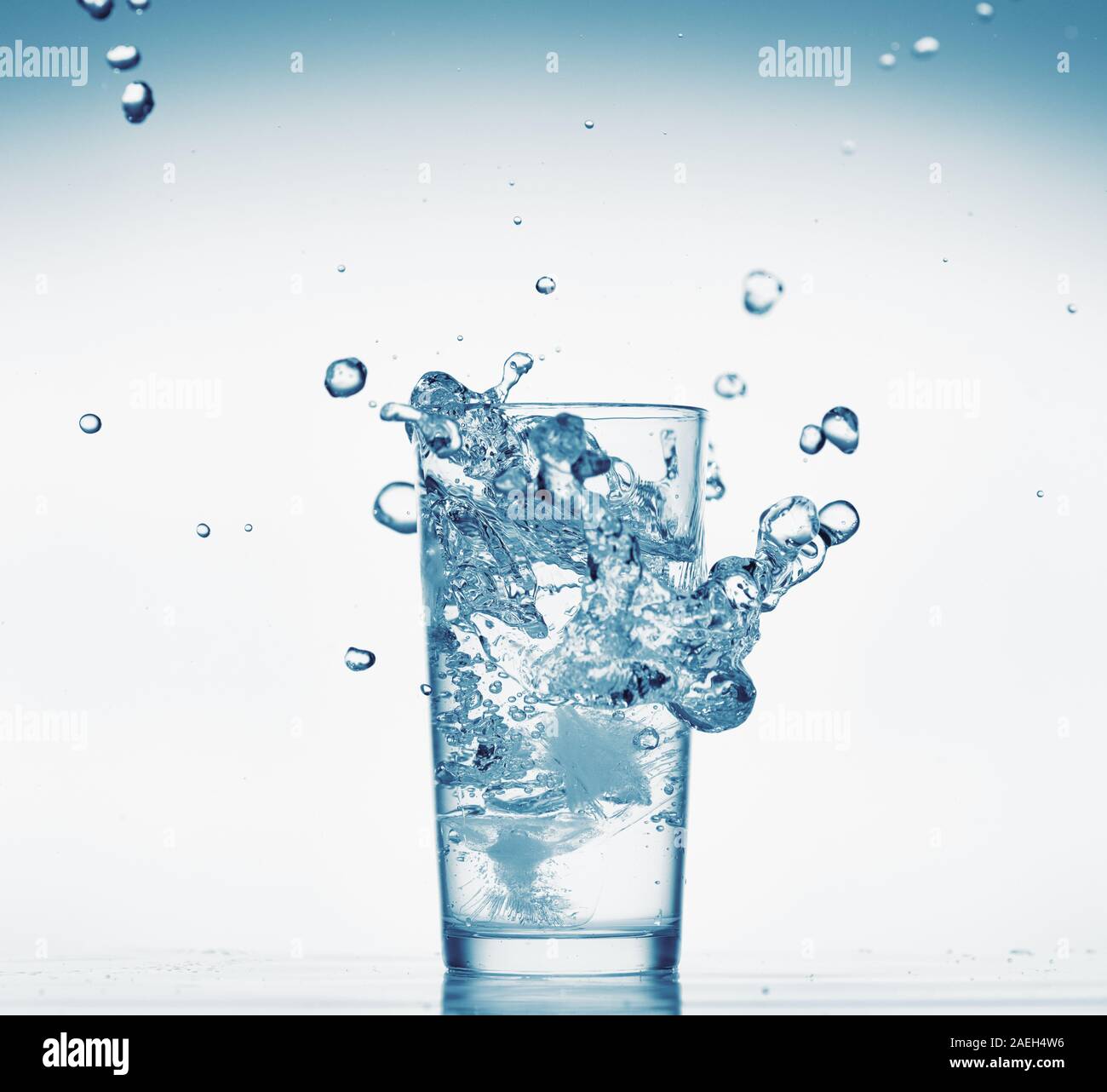 one glass of water with splash from falling ice cube, white background, isolated object Stock ...