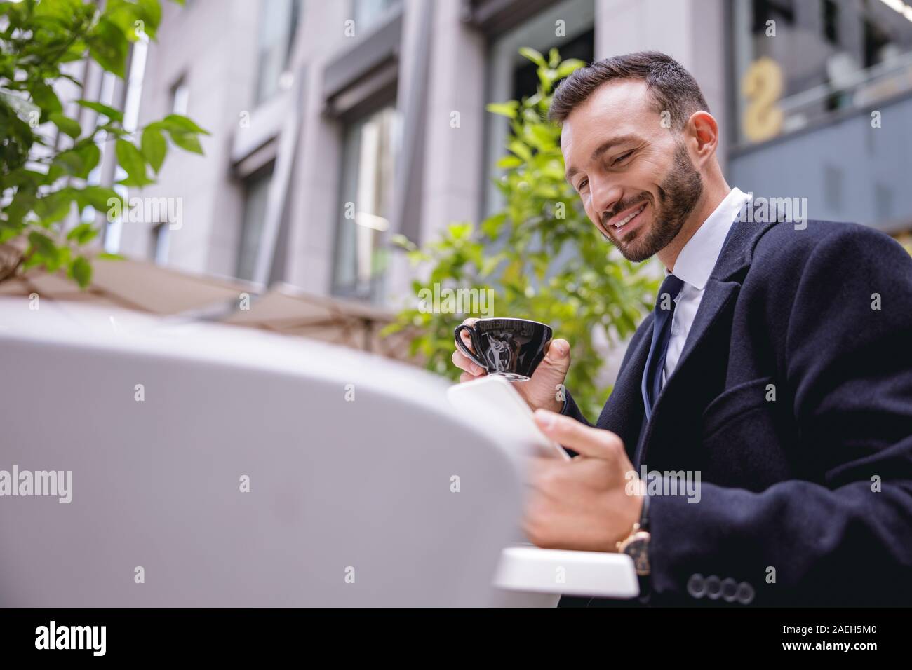 Positive delighted businessman waiting for his partner Stock Photo - Alamy