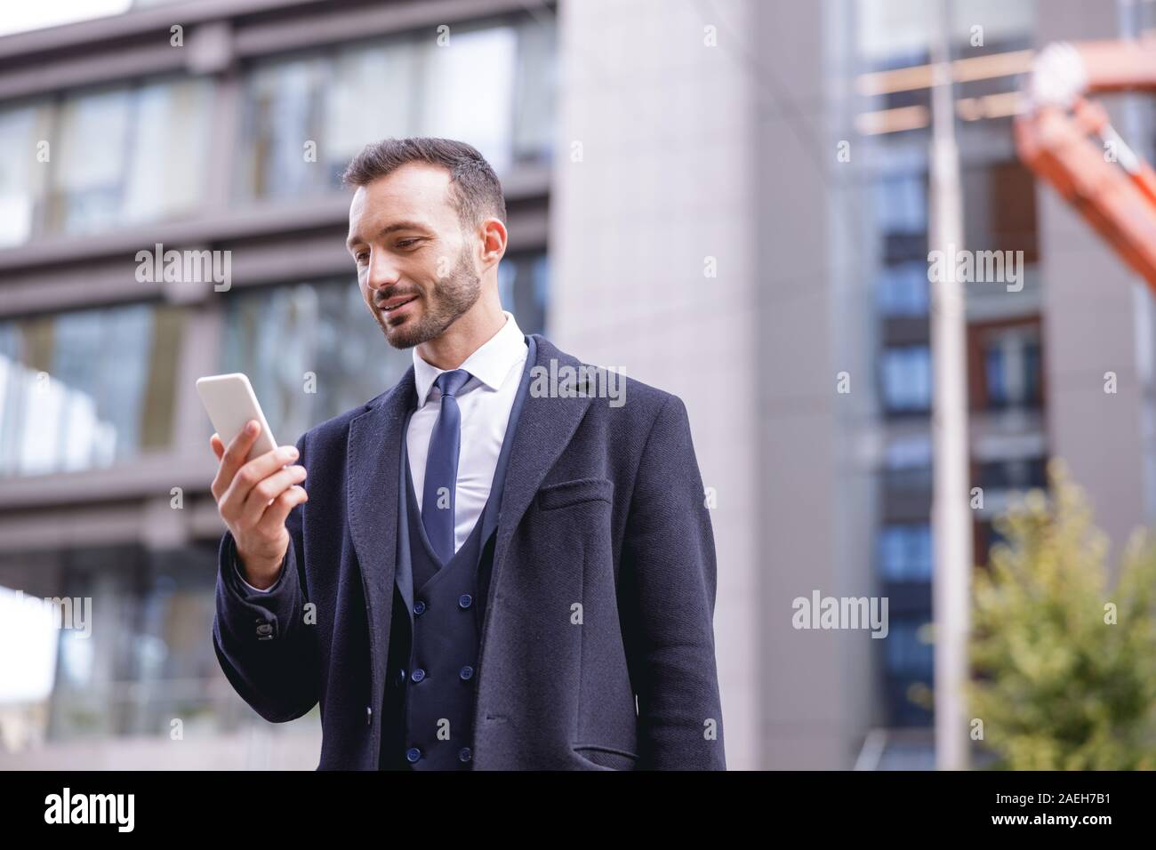 Pleased young businessman waiting for his partner Stock Photo - Alamy