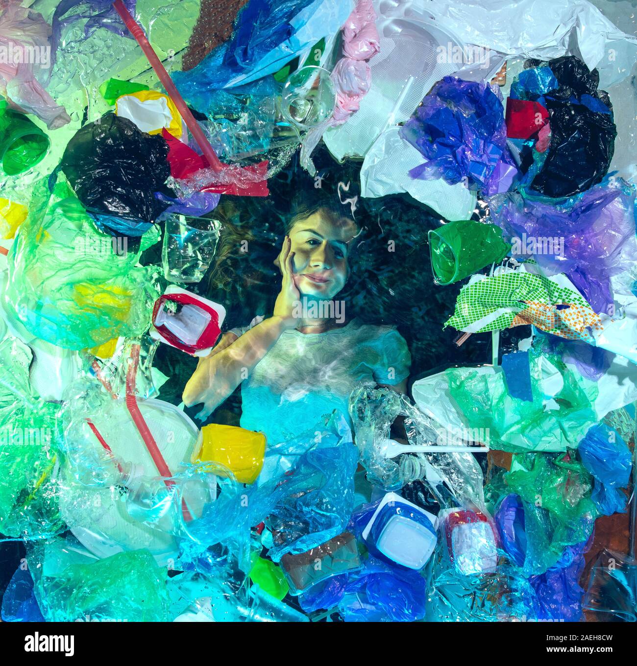 Woman drowning in water under plastic recipients pile, garbage. Used ...