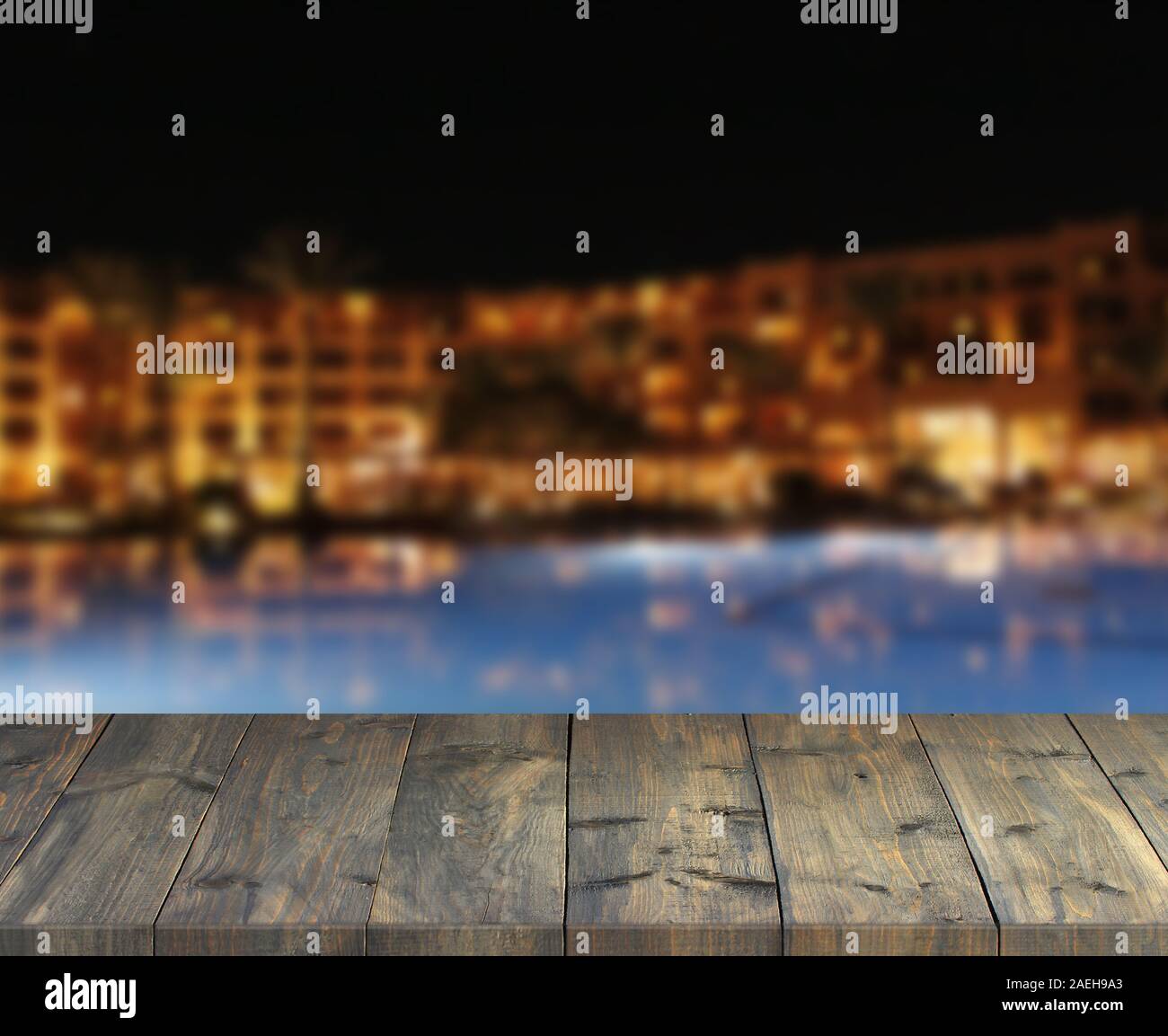 Empty wooden plank with view to evening tropic party. Table top with at ...
