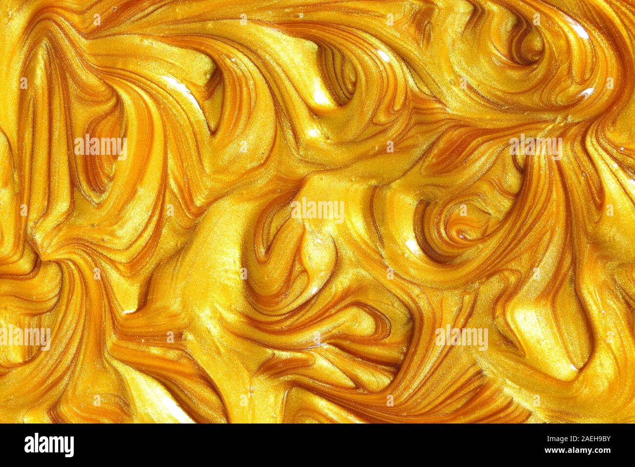 Close up liquid luxury gold metallic glitter paint swirls to make an ...