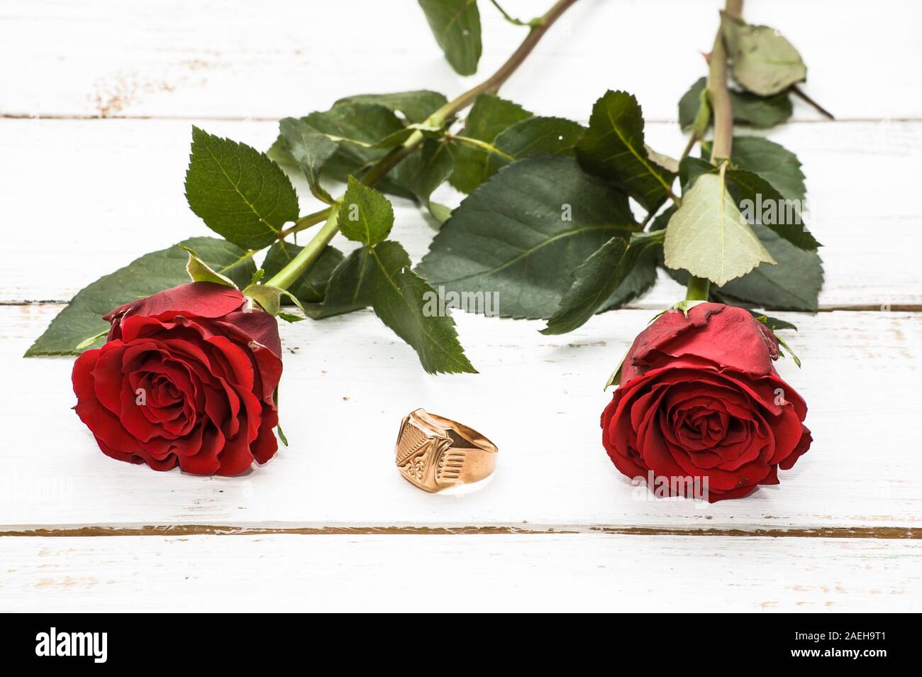 Red roses and engagement ring on wooden background, wedding invitation ...