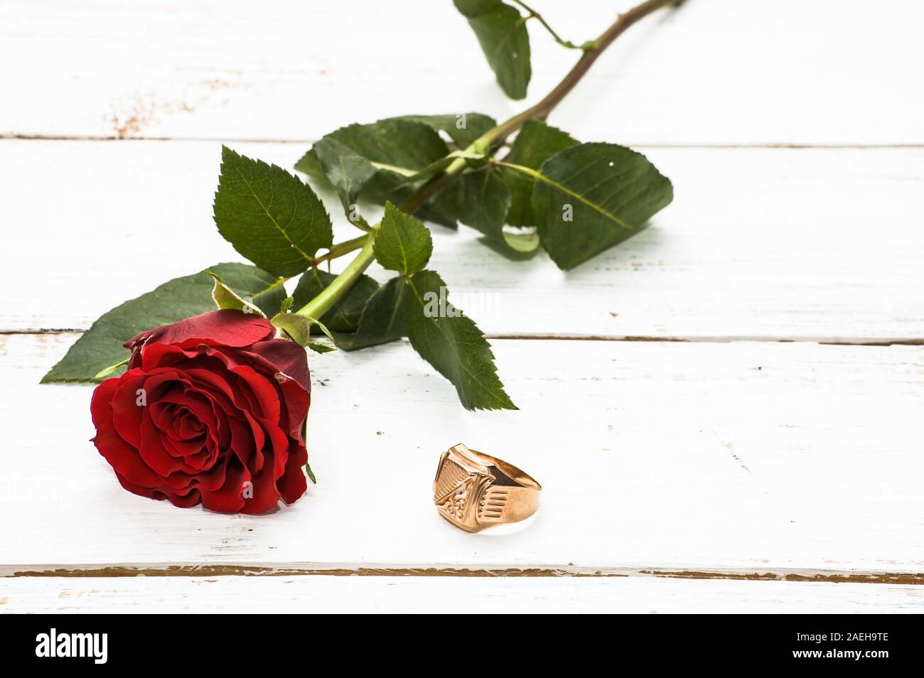 Red rose and engagement ring on wooden background, wedding invitation ...