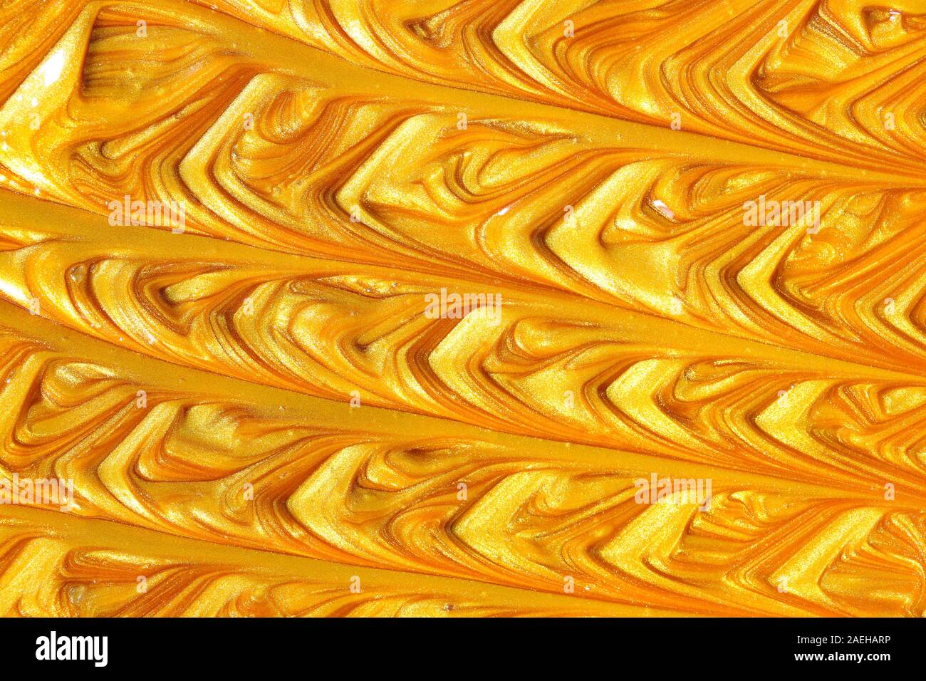 Close up liquid luxury gold metallic glitter paint swirls to make an ...