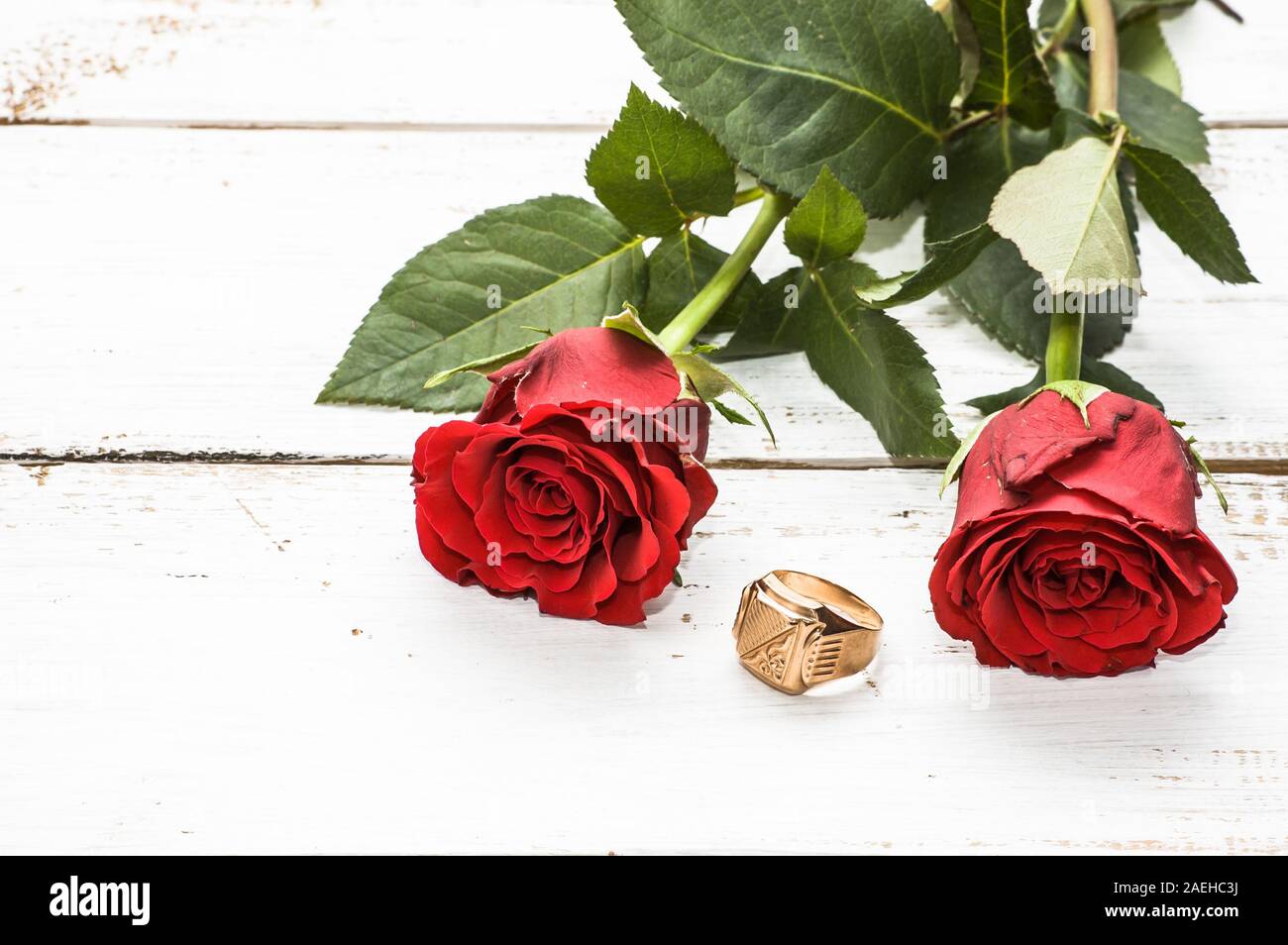 Red roses and engagement ring on wooden background, wedding invitation ...