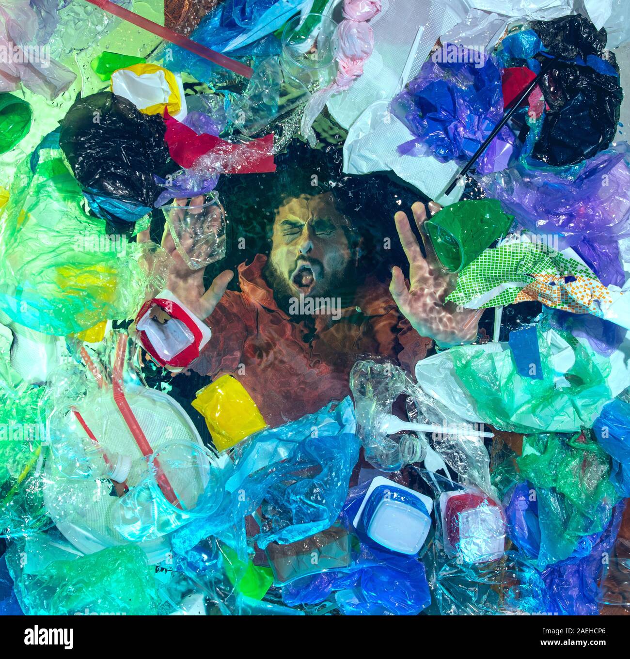 Man drowning in water under plastic recipients pile, garbage. Used ...