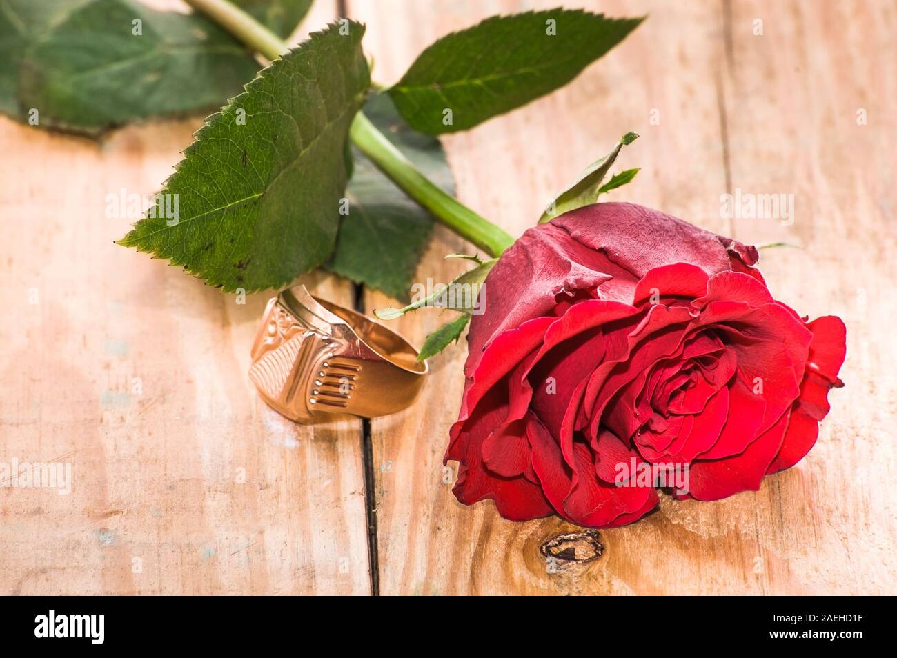 Red roses and engagement ring on wooden background, wedding invitation ...