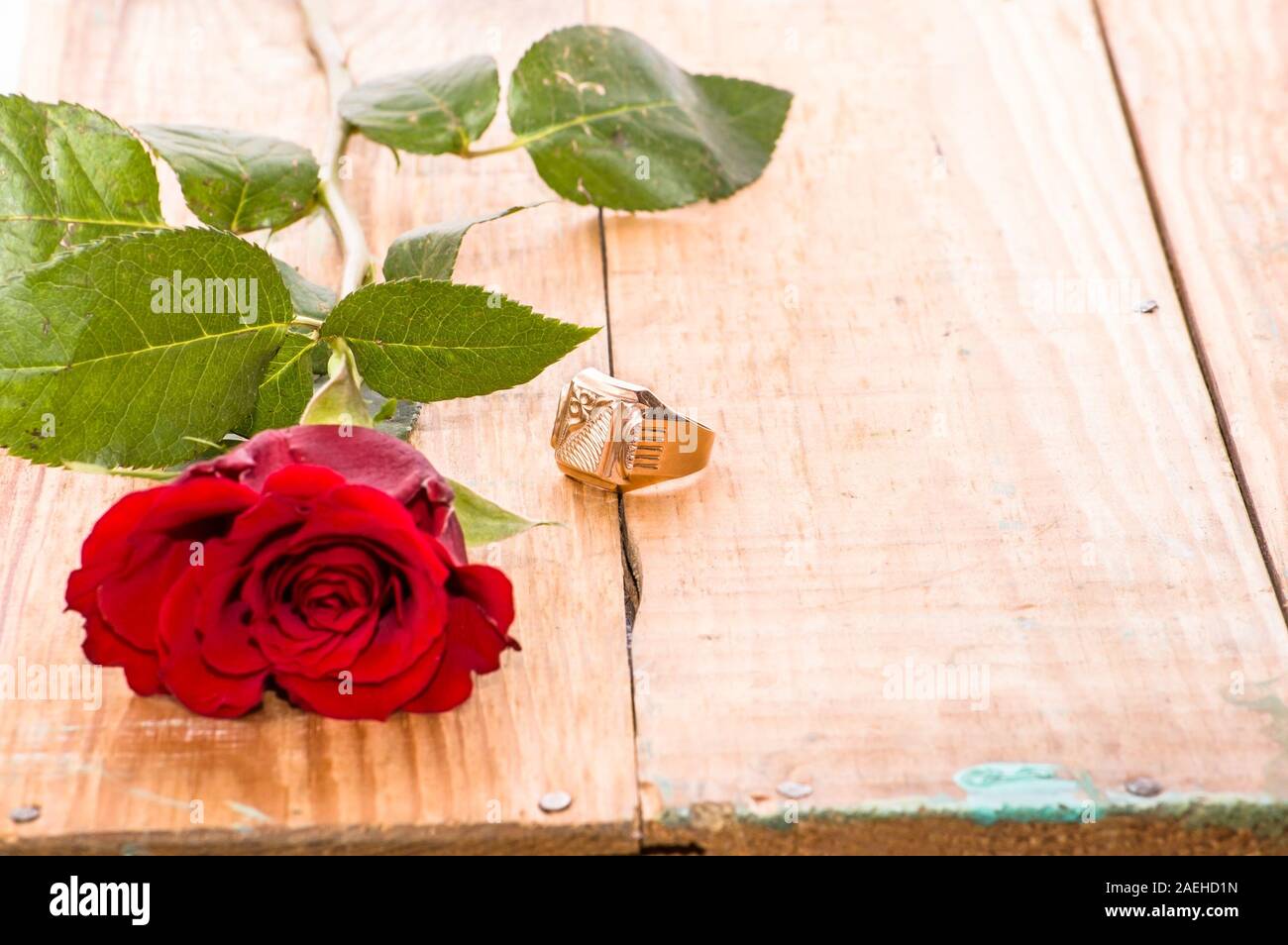 Red roses and engagement ring on wooden background, wedding invitation ...