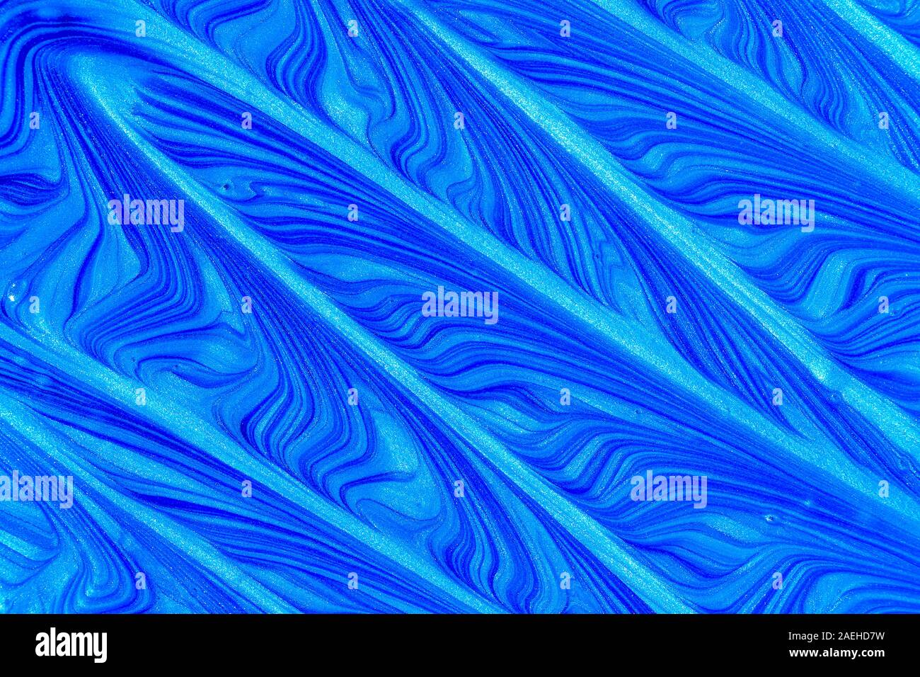 Close up liquid luxury blue metallic glitter paint swirls to make an ...