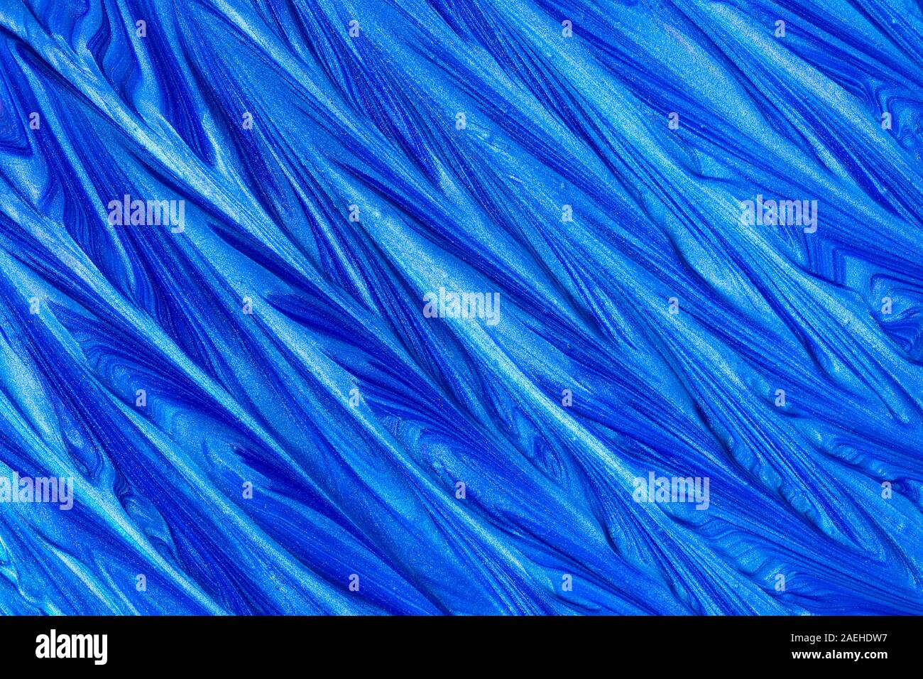 Close up liquid luxury blue metallic glitter paint swirls to make an ...