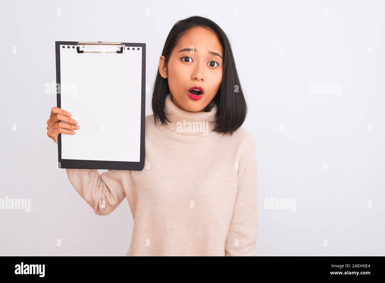 Young chinese inspector woman holding clipboard standing over isolated ...