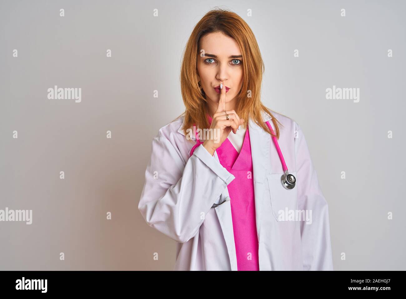 Redhead caucasian doctor woman wearing pink stethoscope over isolated ...