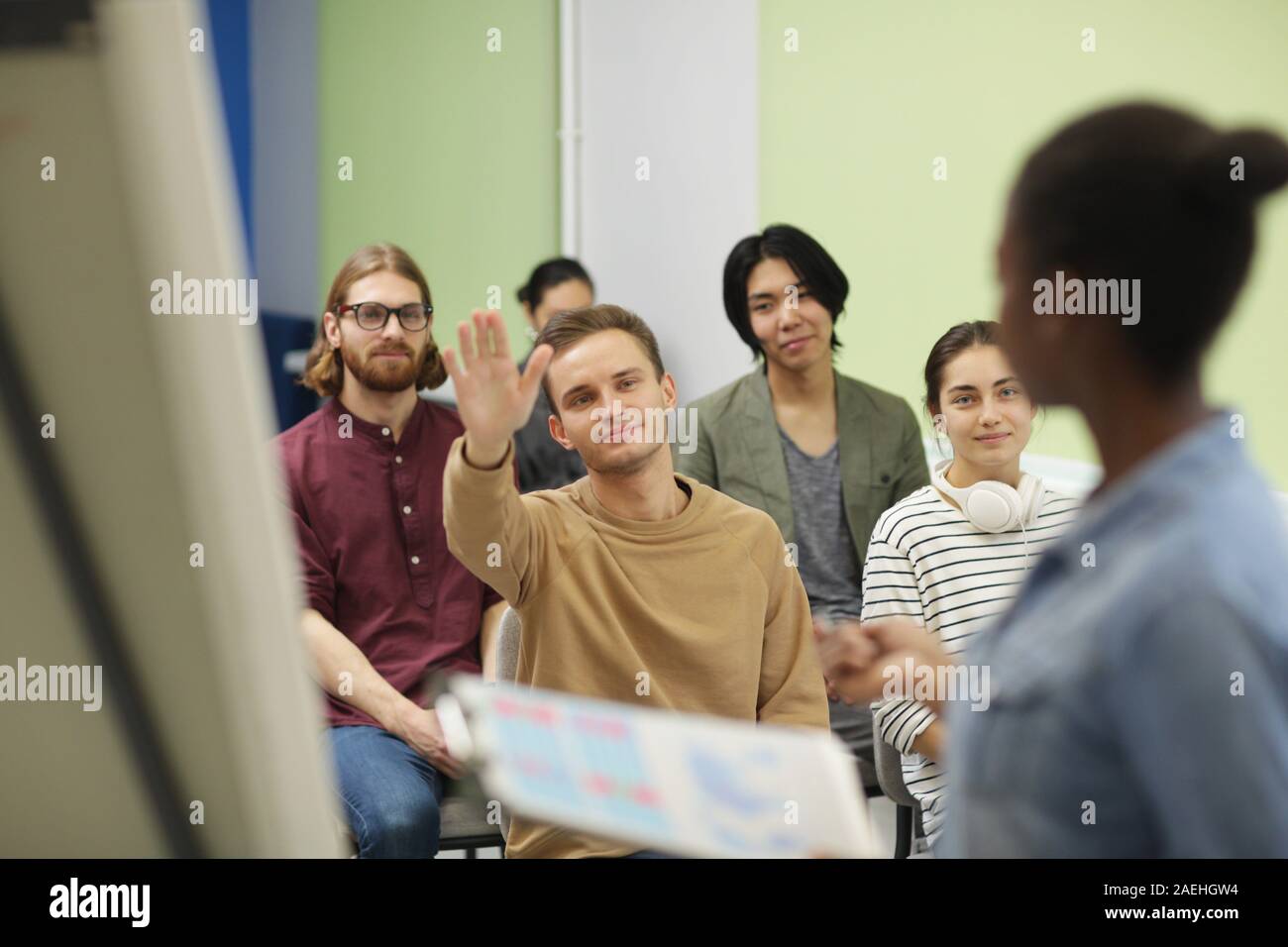 Young man raised his arm he is going to ask question while teacher ...