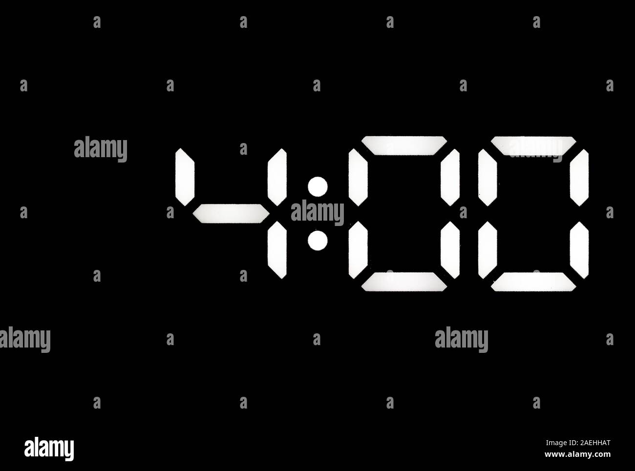 Real white led digital clock on a black background showing time 4:00 ...