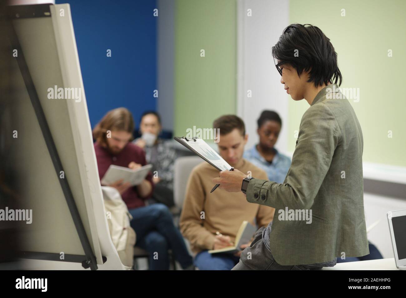 Asian young teacher holding report and reading a lecture while students ...