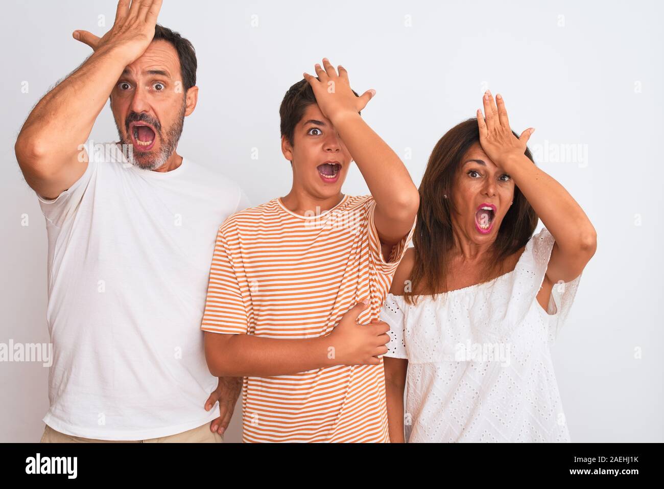 Family of three, mother, father and son standing over white isolated ...