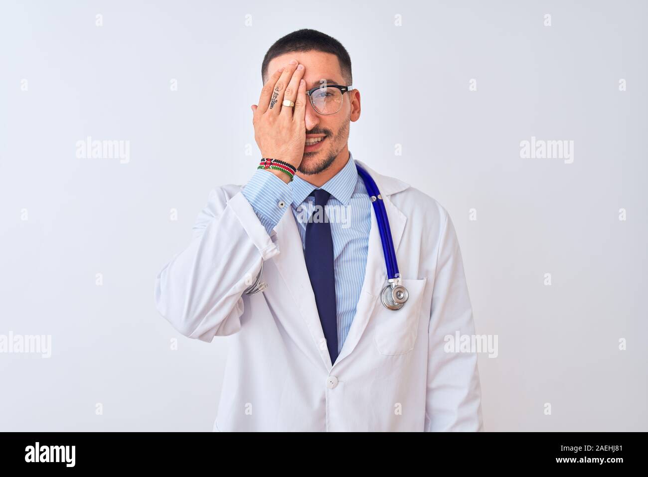 Young doctor man wearing stethoscope over isolated background covering ...