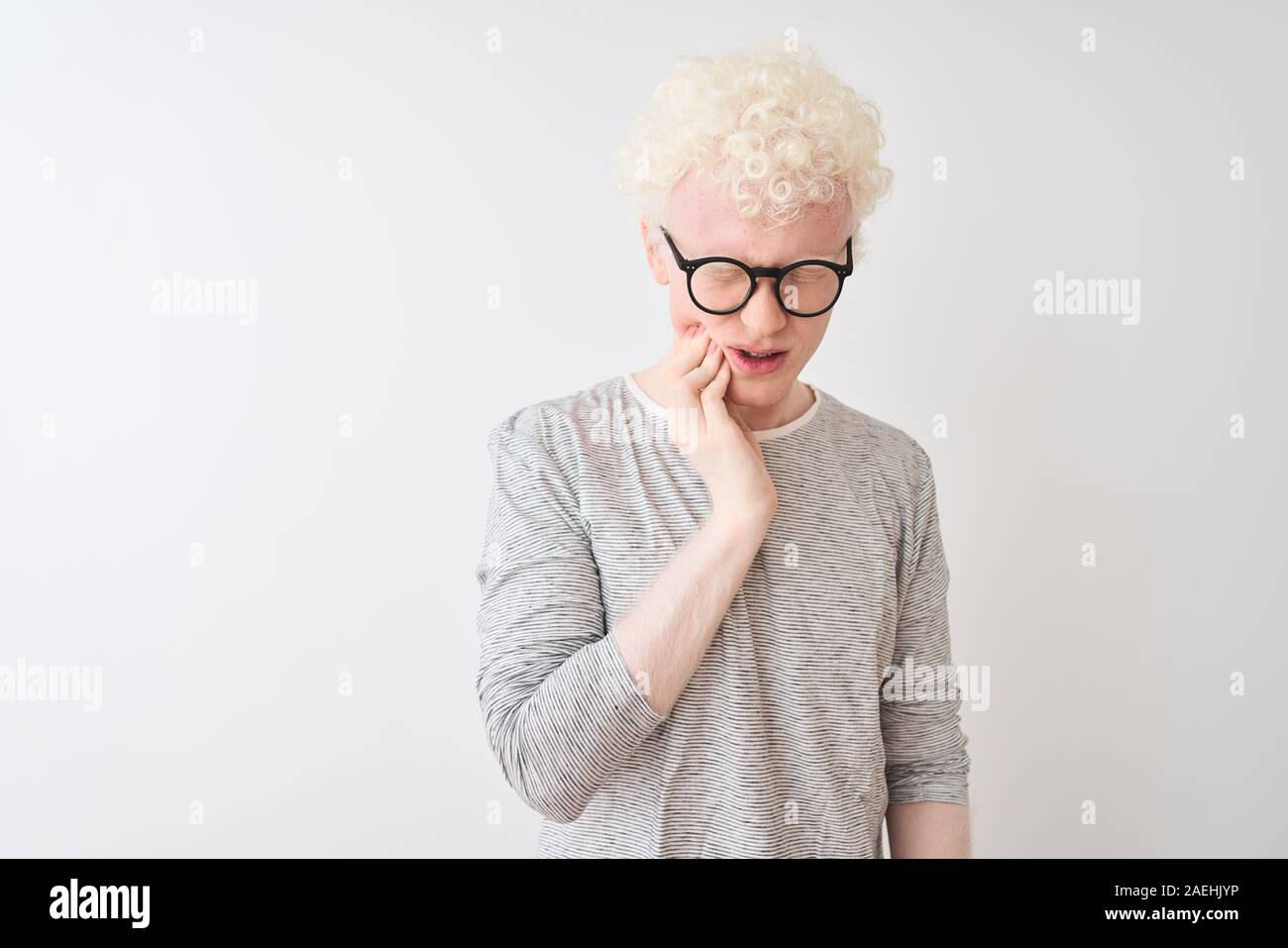 Young albino blond man wearing striped t-shirt and glasses over ...
