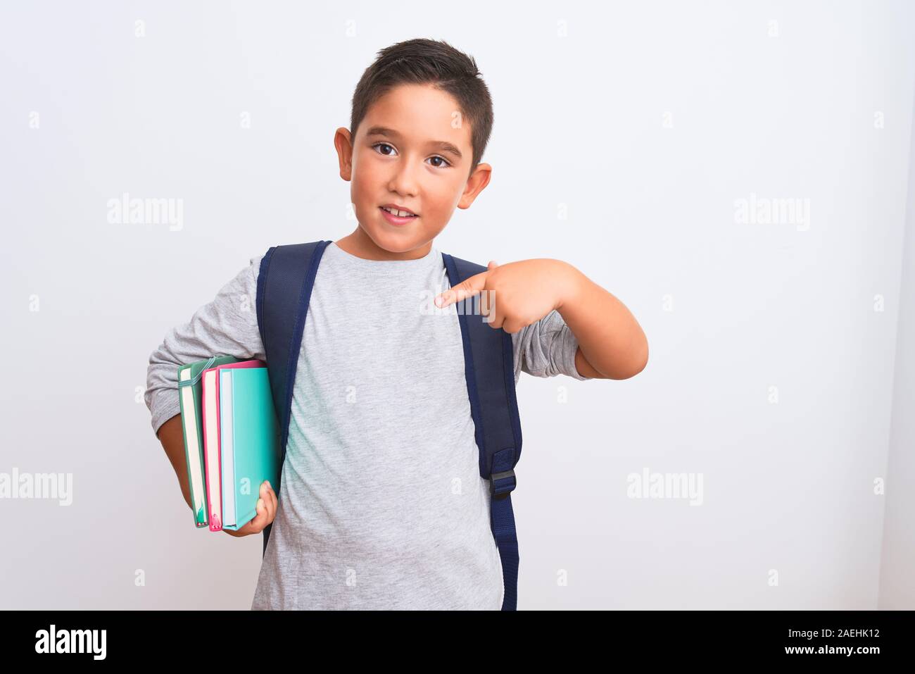 Beautiful student kid boy wearing backpack holding books over isolated ...
