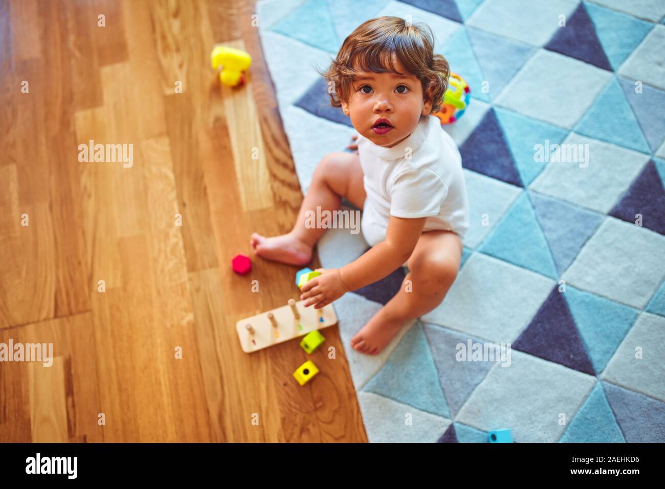 Beautiful toddler child girl playing with toys on the carpet Stock ...