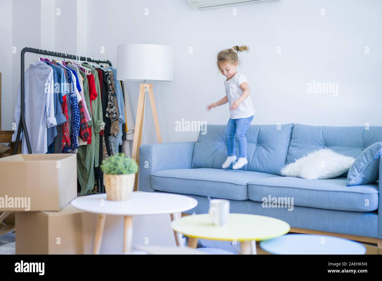 Beautiful toddler child girl jumping on the sofa Stock Photo - Alamy