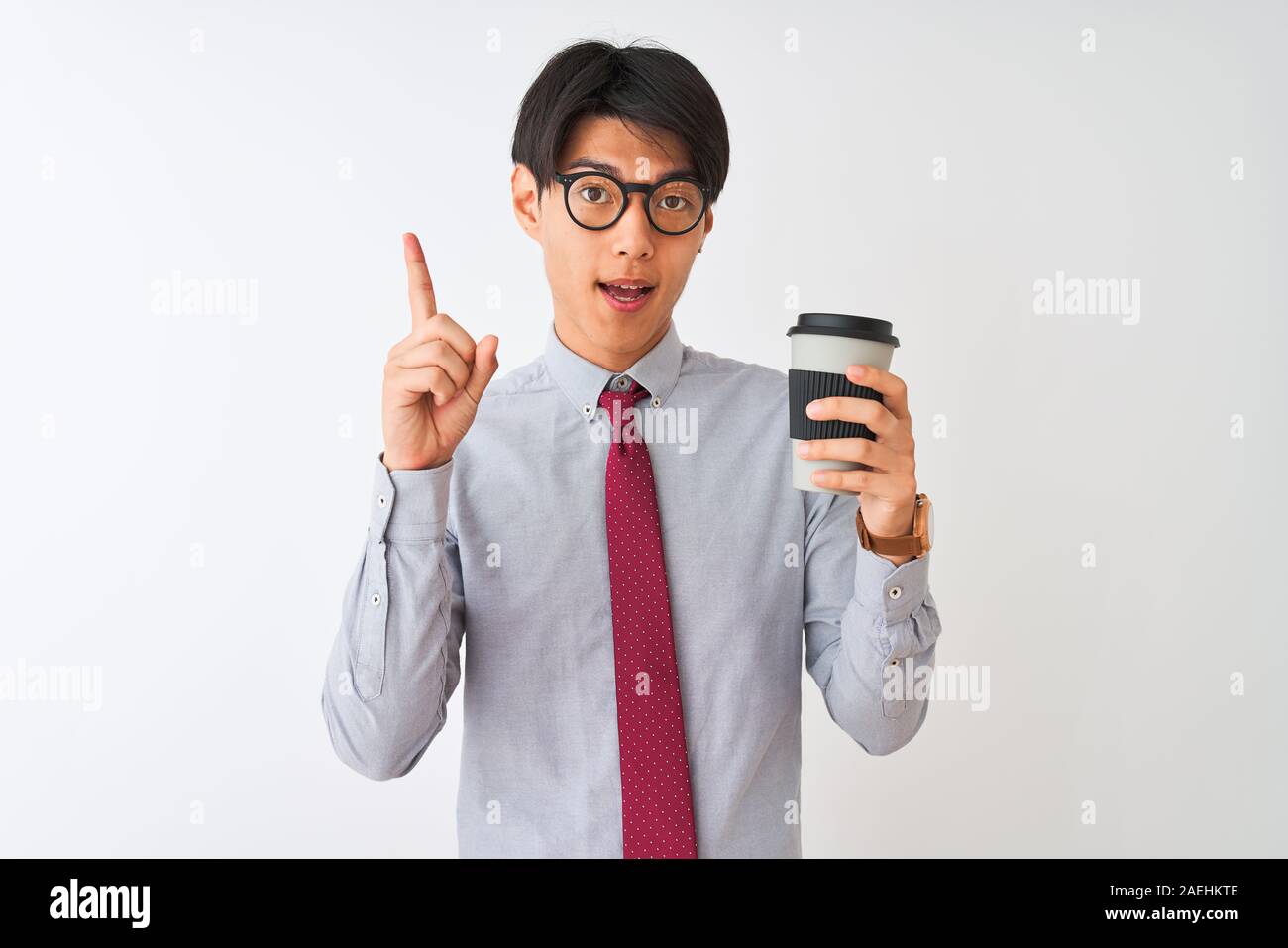 Chinese businessman wearing tie and glasses drinking coffee over ...