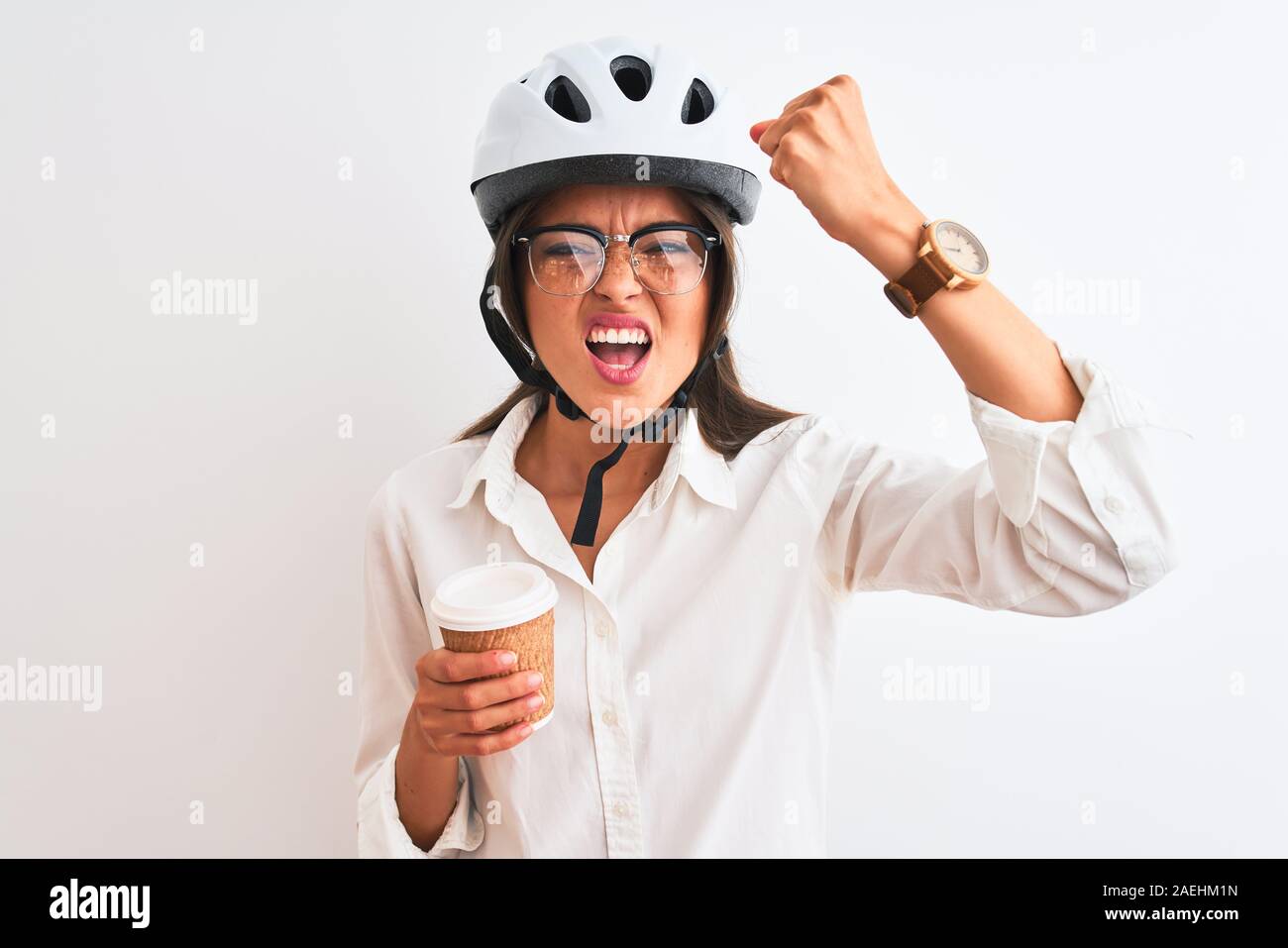 Beautiful businesswoman wearing bike helmet drinking coffee over isolated white background ...
