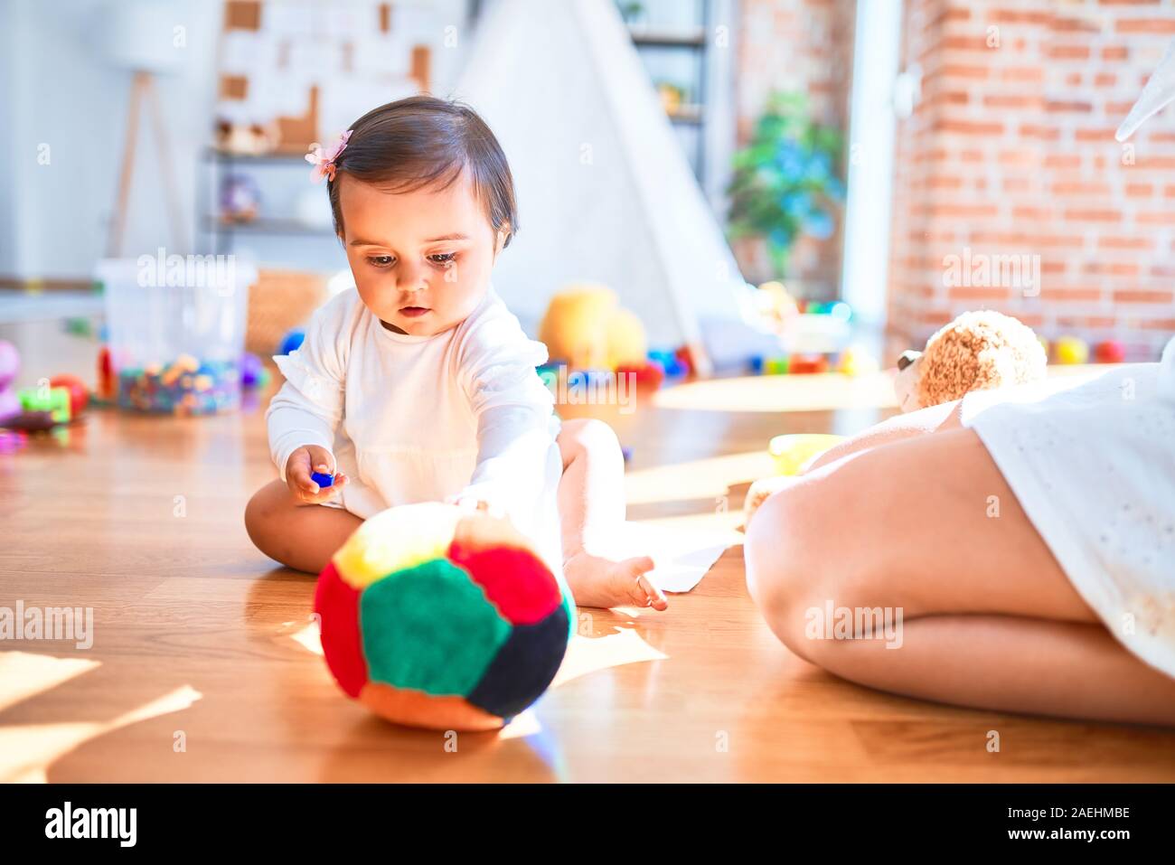 Beautiful infant happy at kindergarten around colorful toys Stock Photo - Alamy