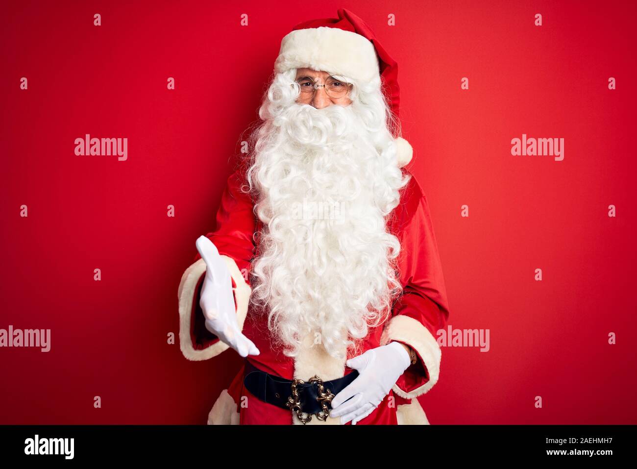 Middle age handsome man wearing Santa costume standing over isolated ...