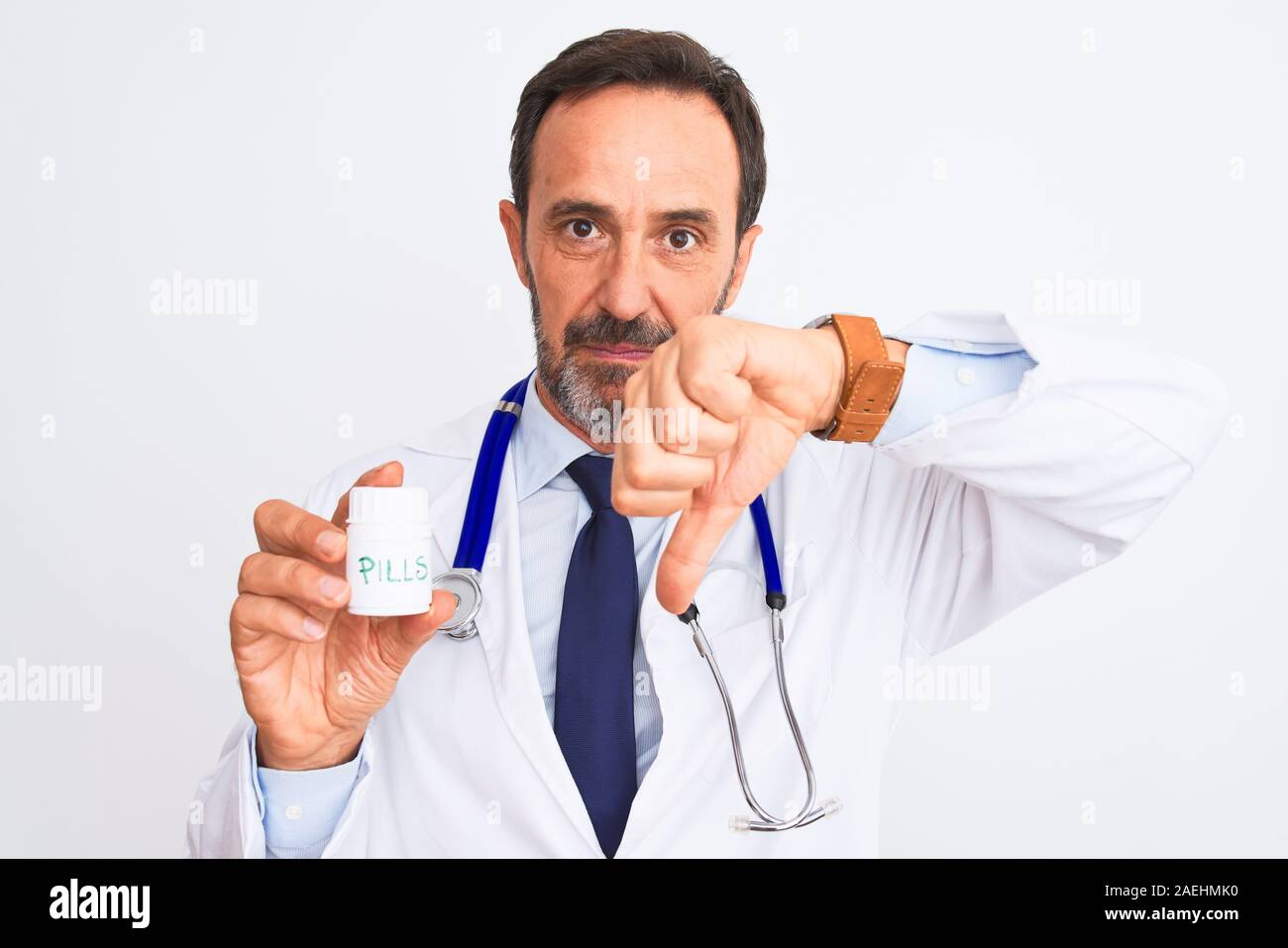 Middle age doctor man holding pills standing over isolated white ...