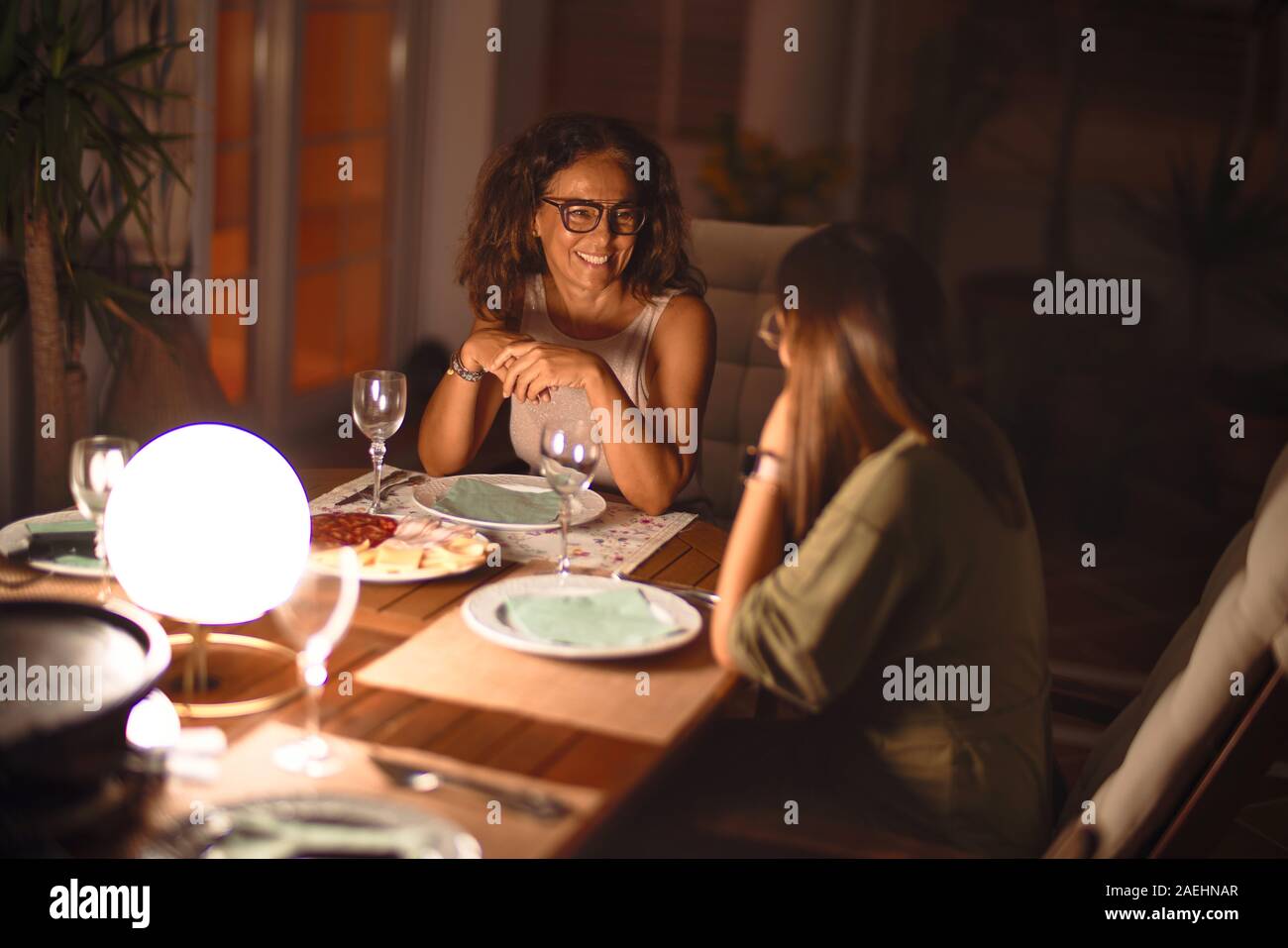 Beautiful mother and daughter on dinner smiling at terrace Stock Photo ...