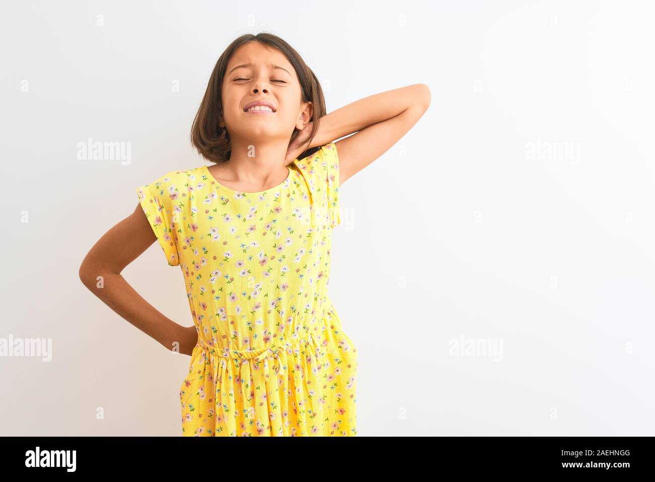 Young beautiful child girl wearing yellow floral dress standing over ...