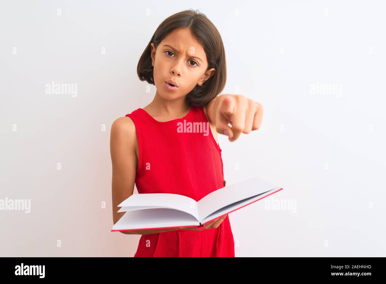 Beautiful student child girl reading red book standing over isolated ...