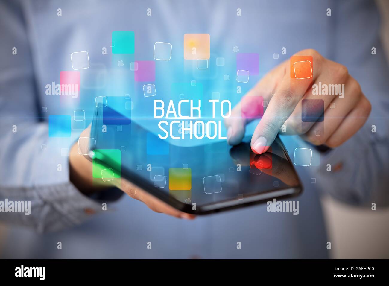 Young man holding a foldable smartphone with BACK TO SCHOOL inscription ...