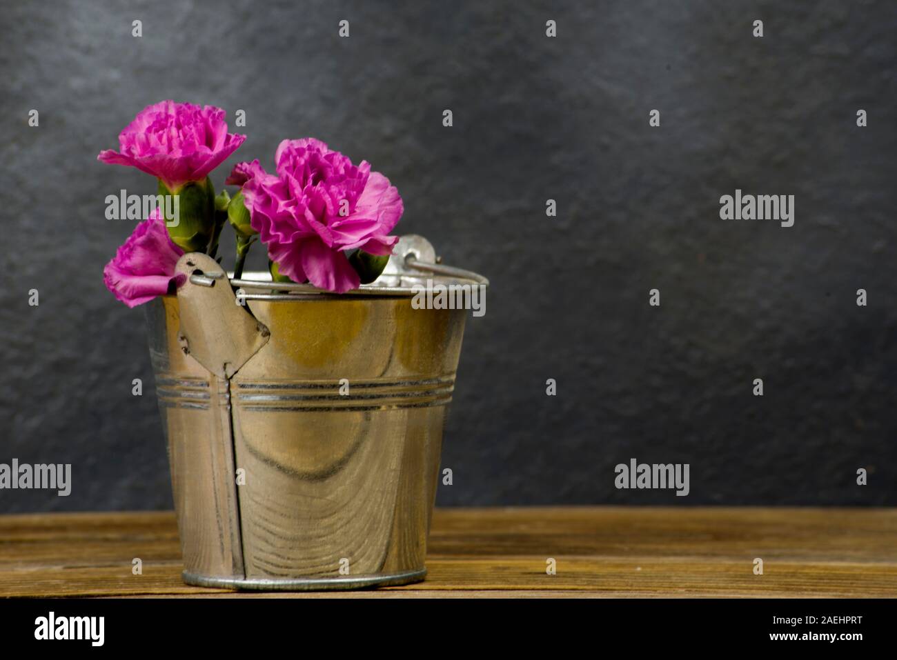 small steel cauldron with flowers on wood Stock Photo - Alamy