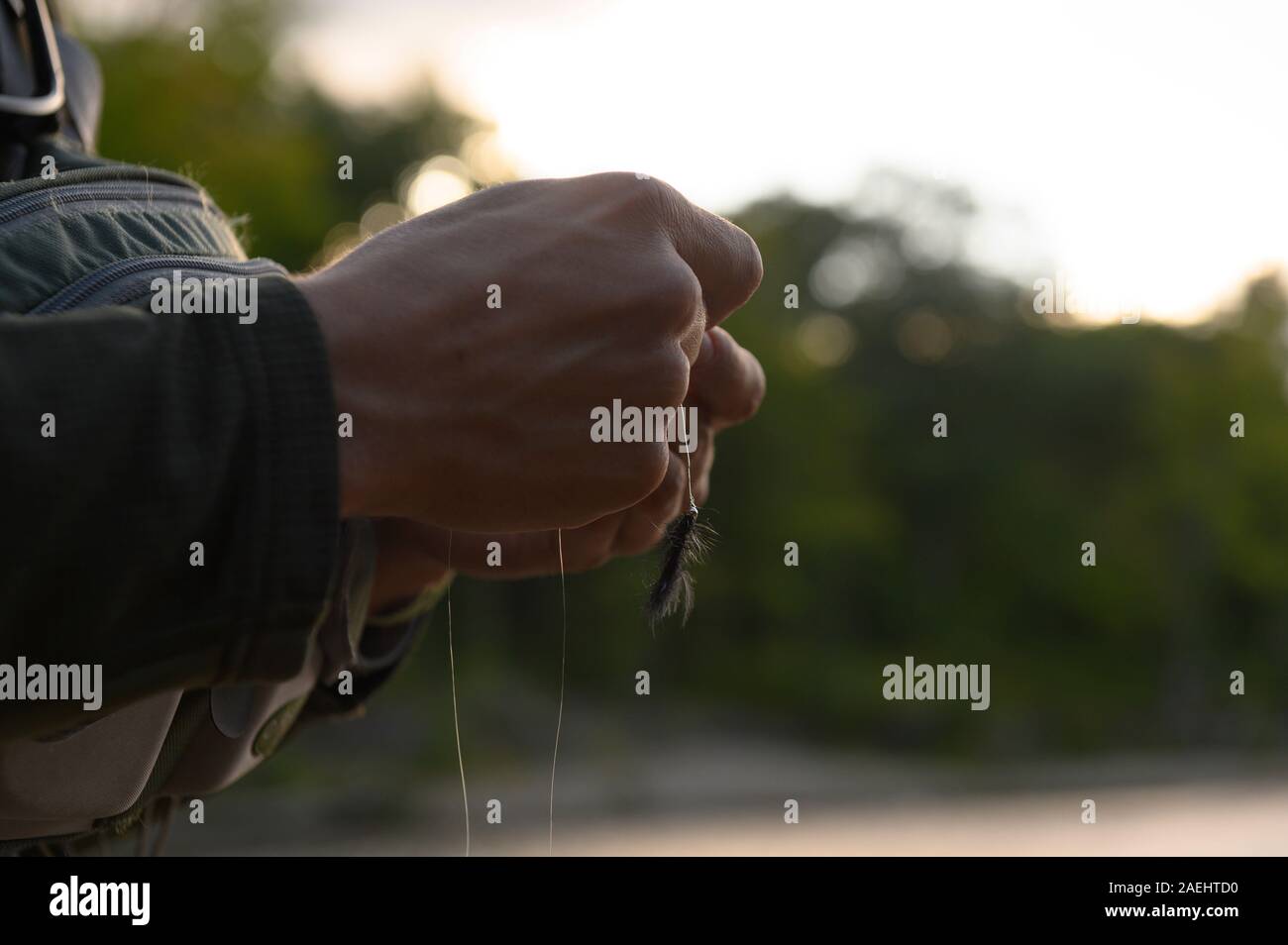 A man tying on an artificial fly called a wooly bugger Stock Photo - Alamy