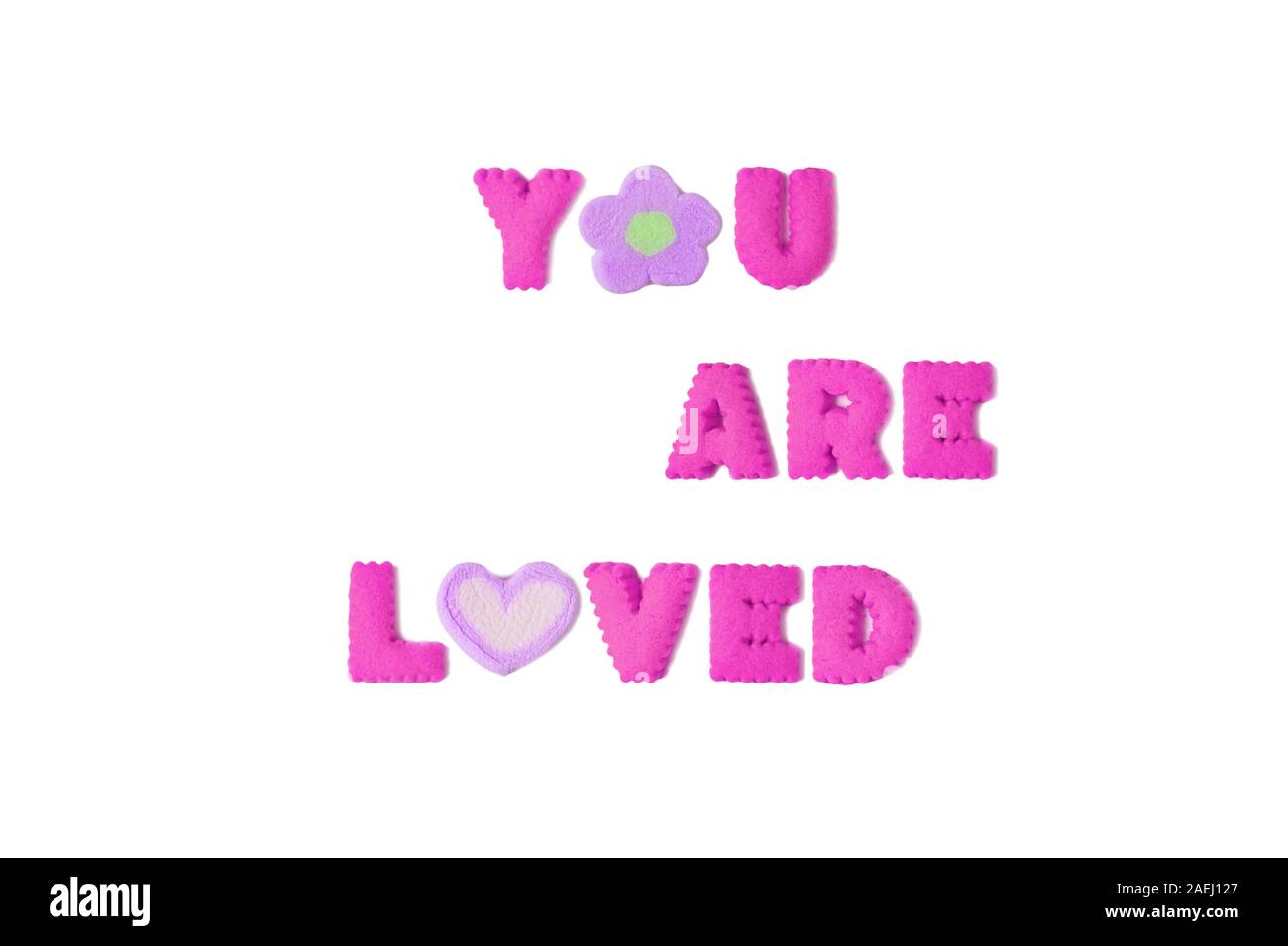 The word YOU ARE LOVED spelled with vivid pink alphabet cookies and ...
