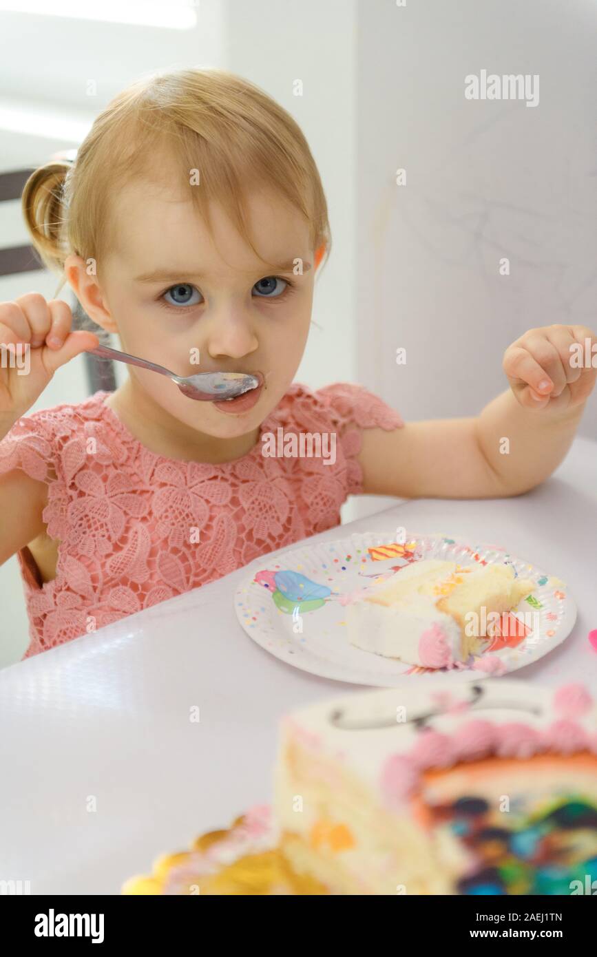 Baby girl 1 year old eating birthday cake in room. Birthday party ...