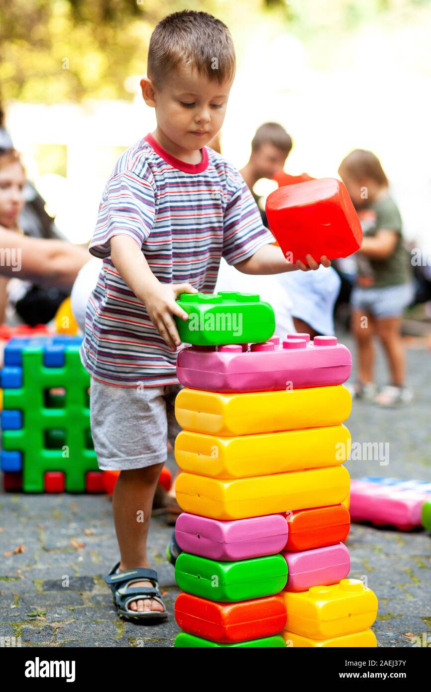 Cute boy playing with buiding toy colorful blocks. Kid with happy face ...