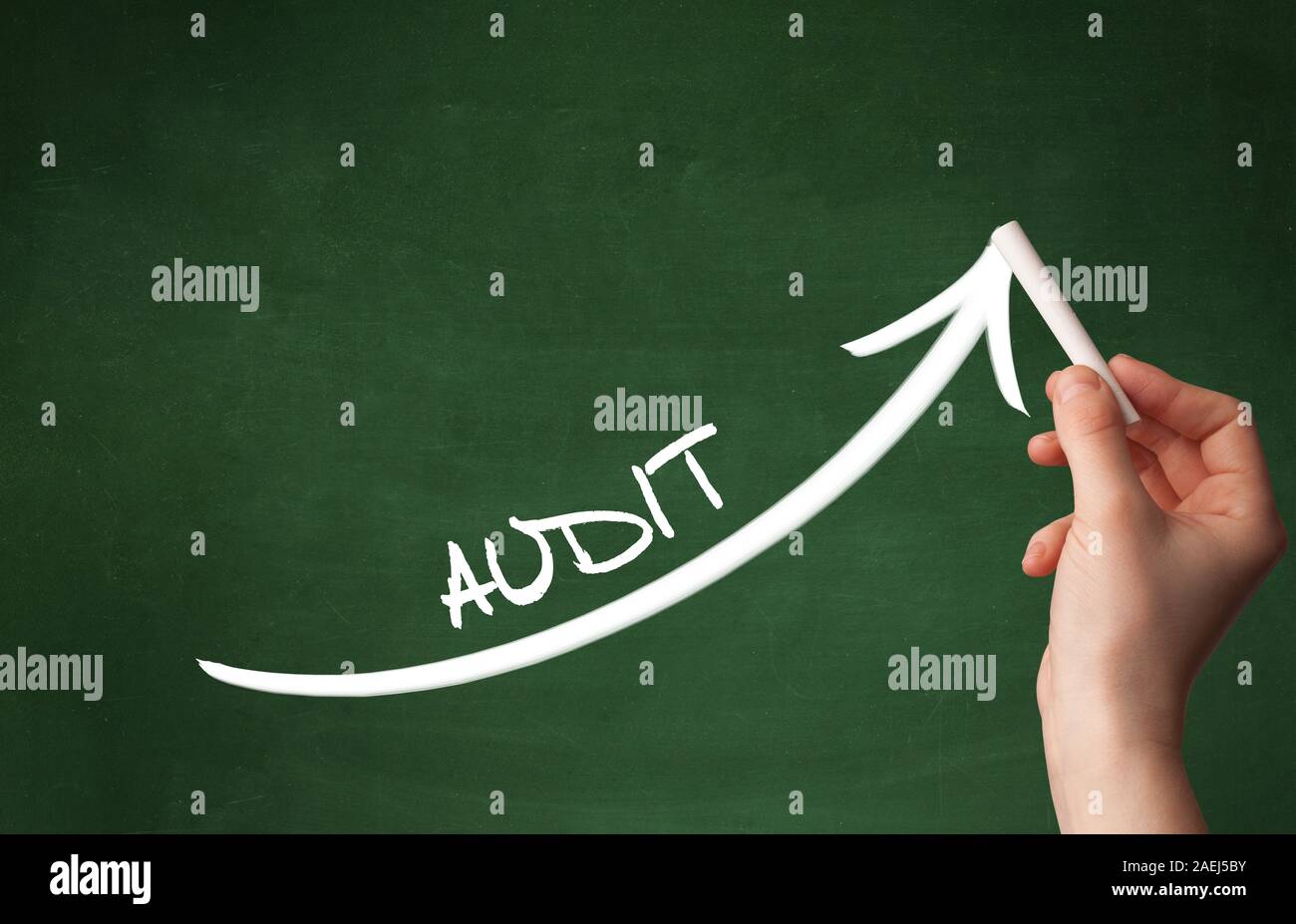 Hand drawing AUDIT inscription with white chalk on blackboard, business ...