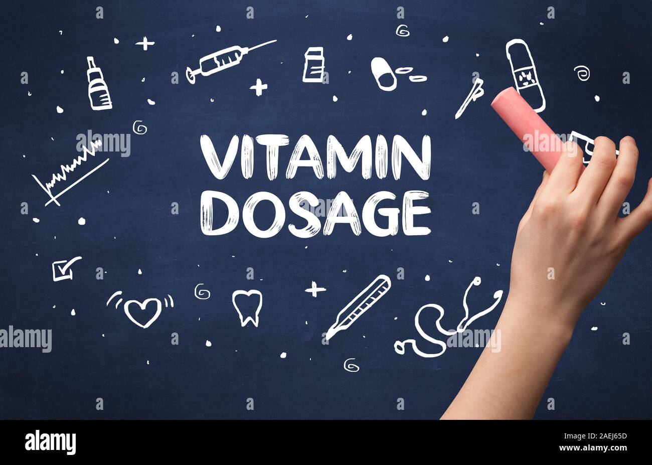 Hand drawing VITAMIN DOSAGE inscription with white chalk on blackboard ...