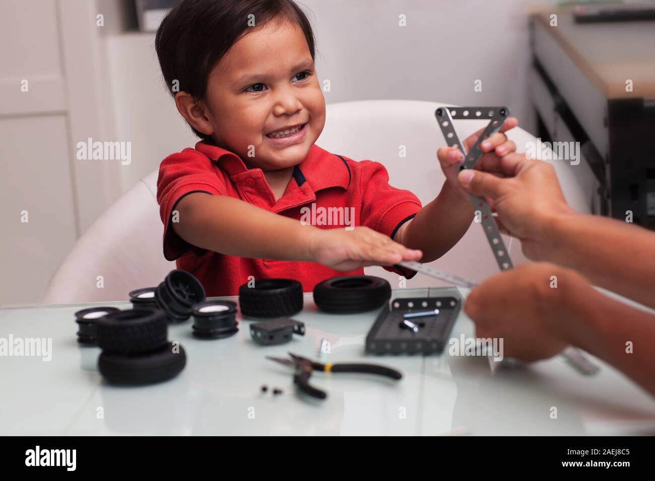 A young boy is happy in helping to build a DIY toy project with the ...