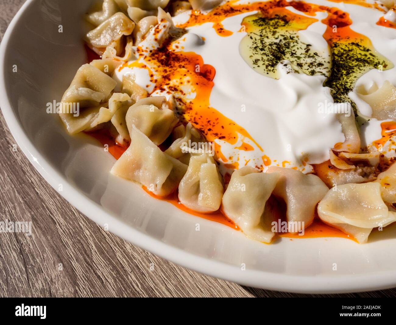 Turkish Manti with red pepper, tomato sauce, yogurt and mint. Plate of ...