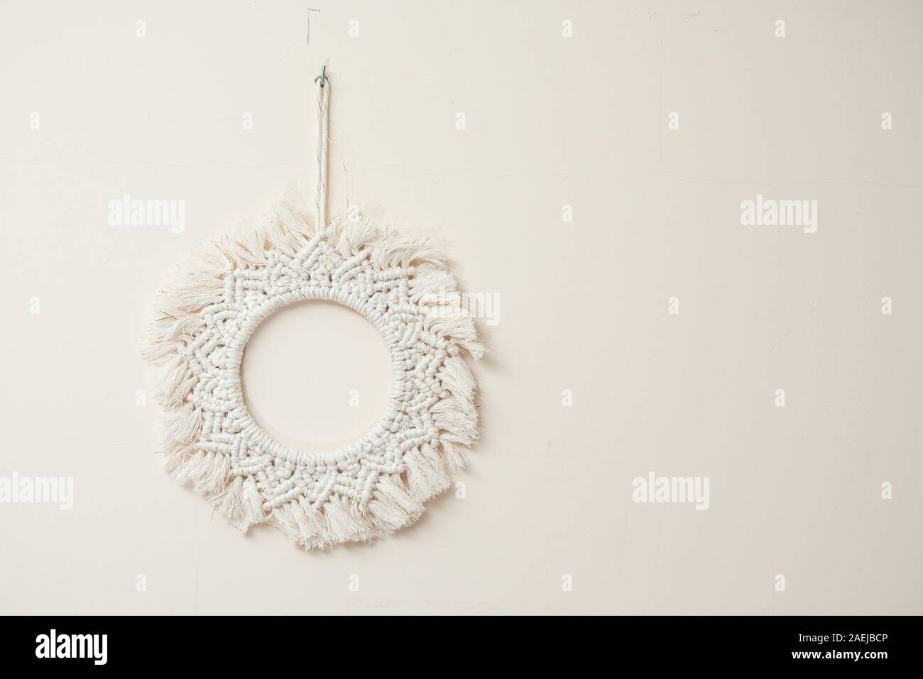 Handmade cotton macrame mandala wall decoration hanging on a wall with ...